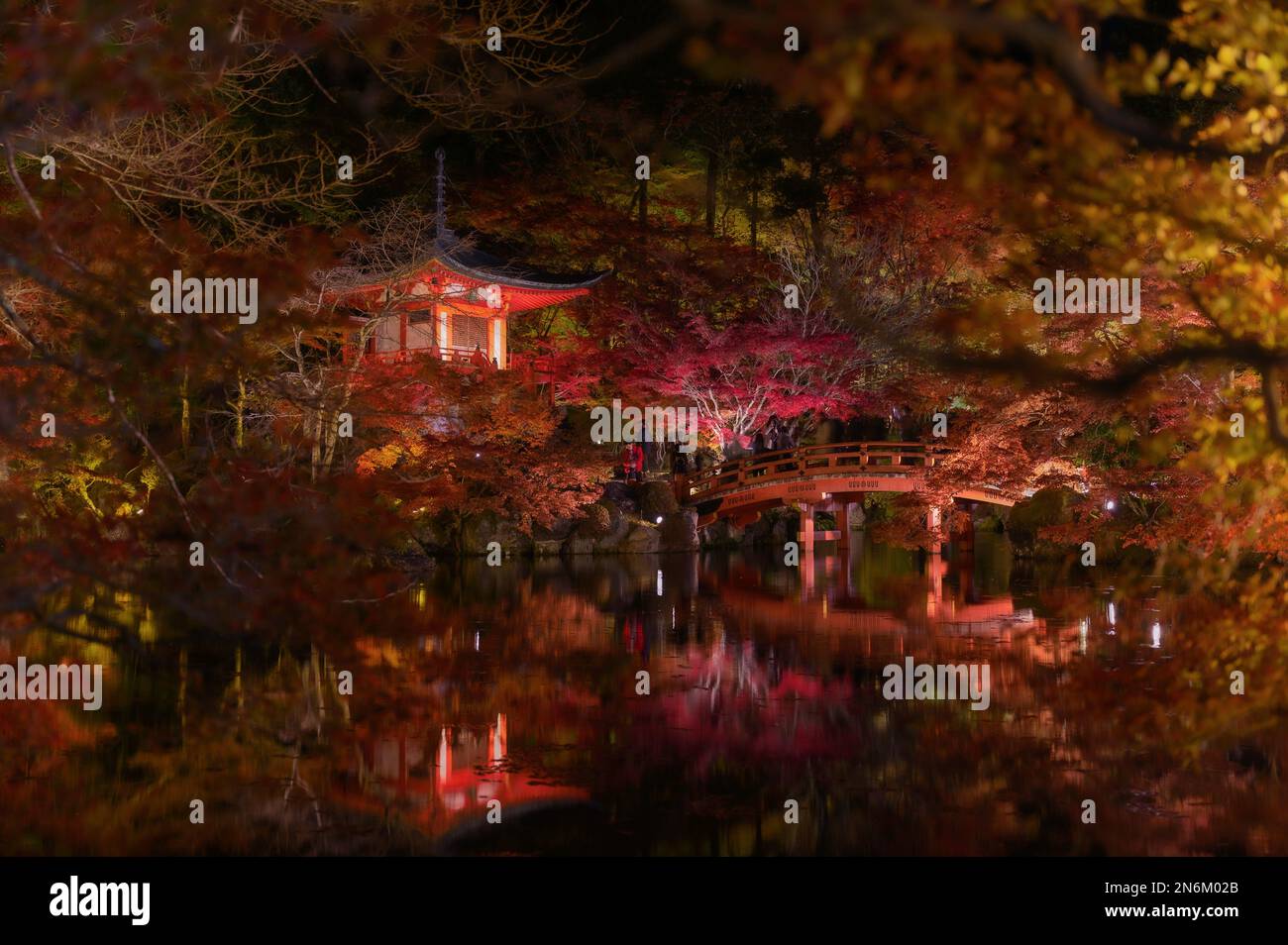 A red bridge and the reflection of colorful fairy trees at night by ...