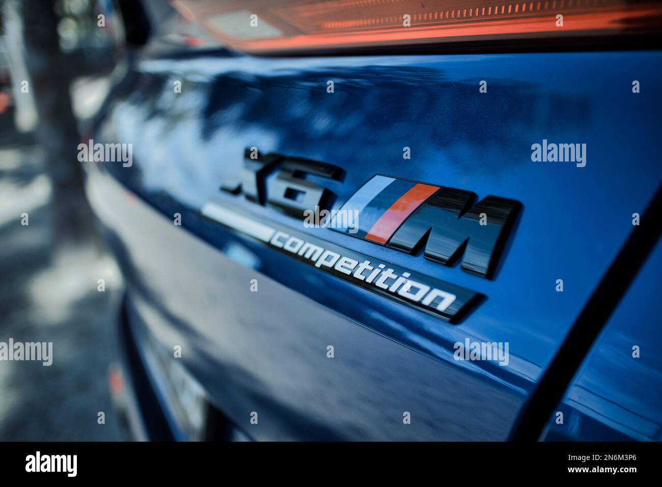 A closeup of the logo of a Blue BMW X6 sports SUV on the backside of ...