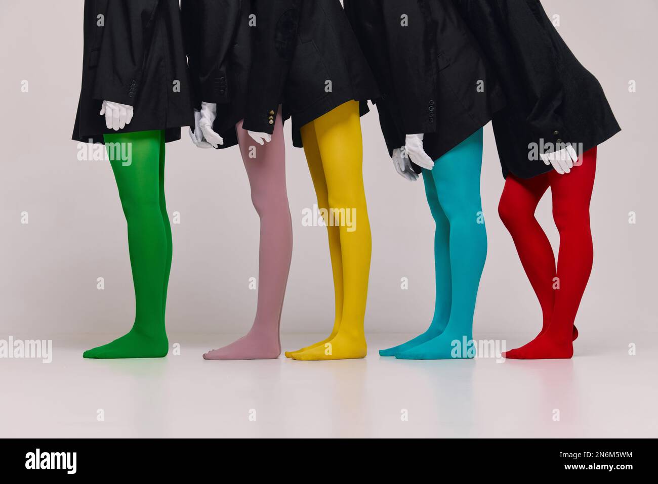 Cropped image of women in black jackets and multi colored tights ...
