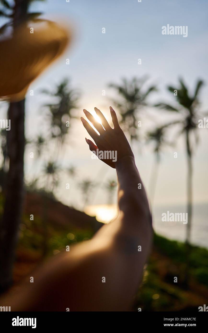 Silhouette of delicate feminine hand covering the sun. Black woman ...