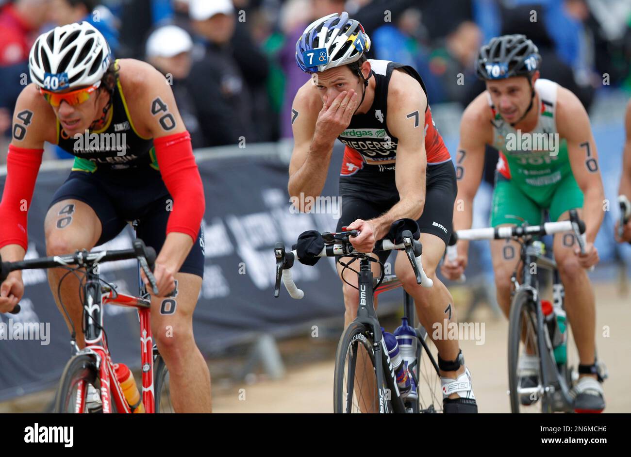 Sven Riederer of Switzerland, center, races in the cycle portion of the ...