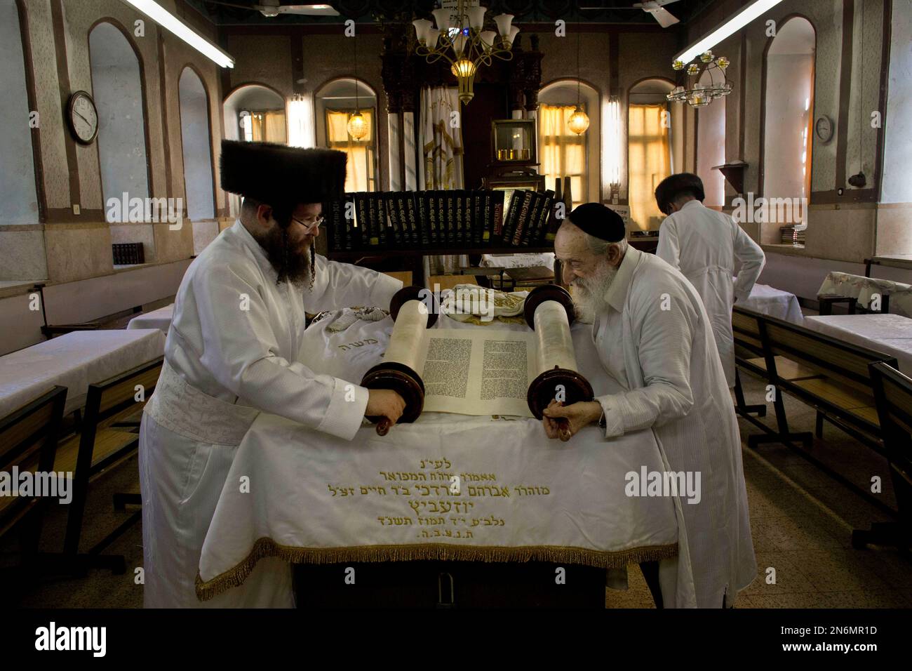 Ultra-Orthodox Jewish men roll a torah scroll ahead of Yom Kippur, in ...