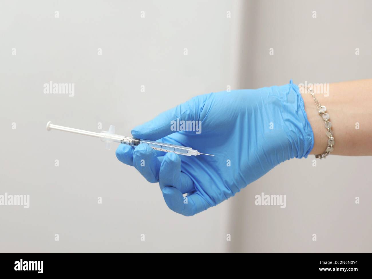 Woman holding medical injection syringe in her outstretched hand ...