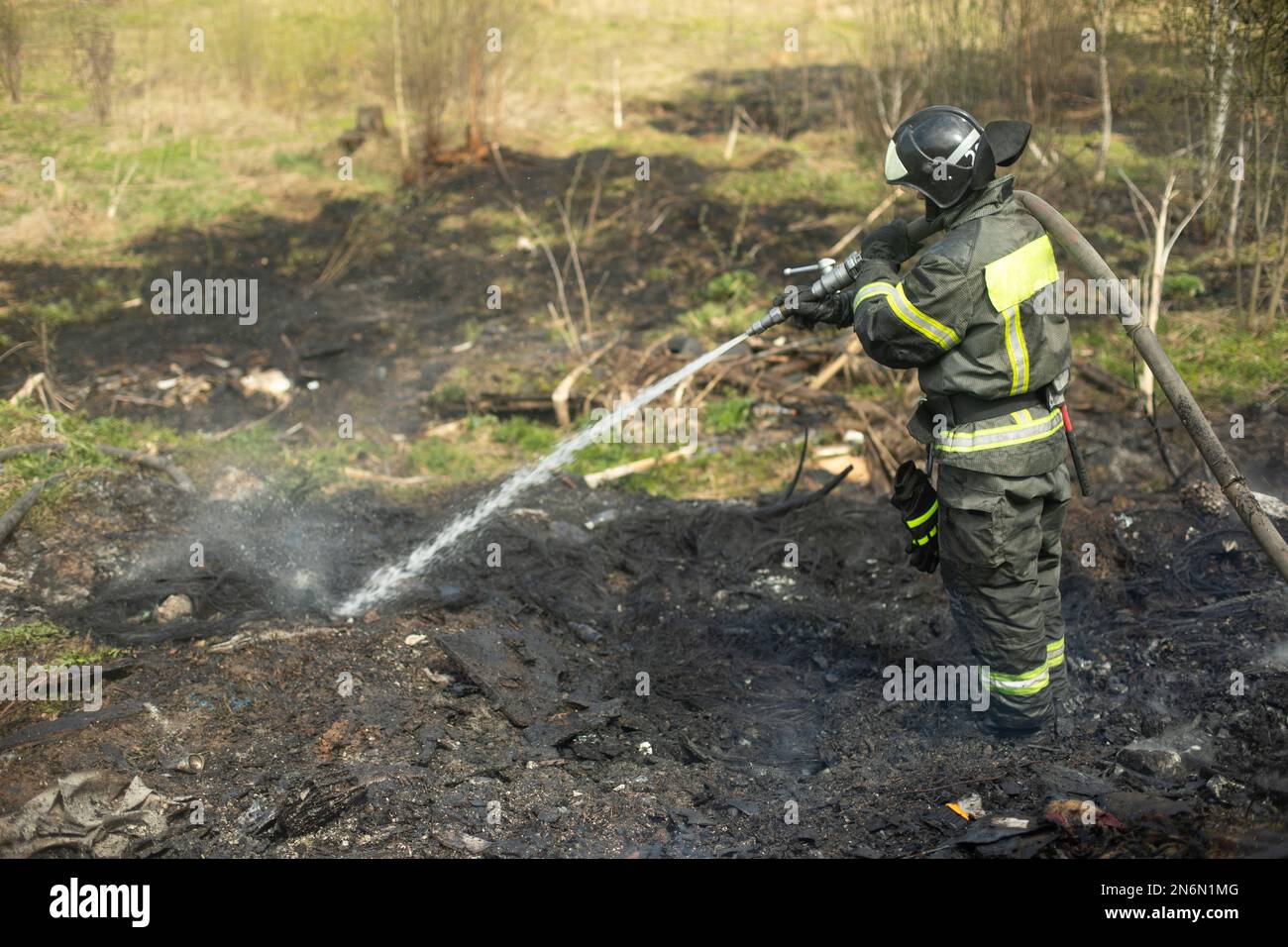 Water pours out of hose. Firefighter holds hydrant. Putting out fire ...