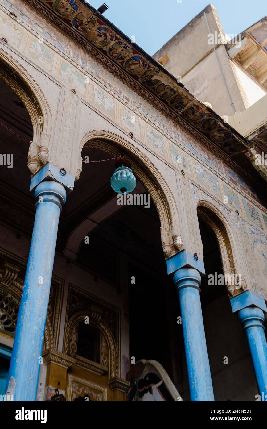 A vertical shot of the arches of a traditional house with blue pillars ...