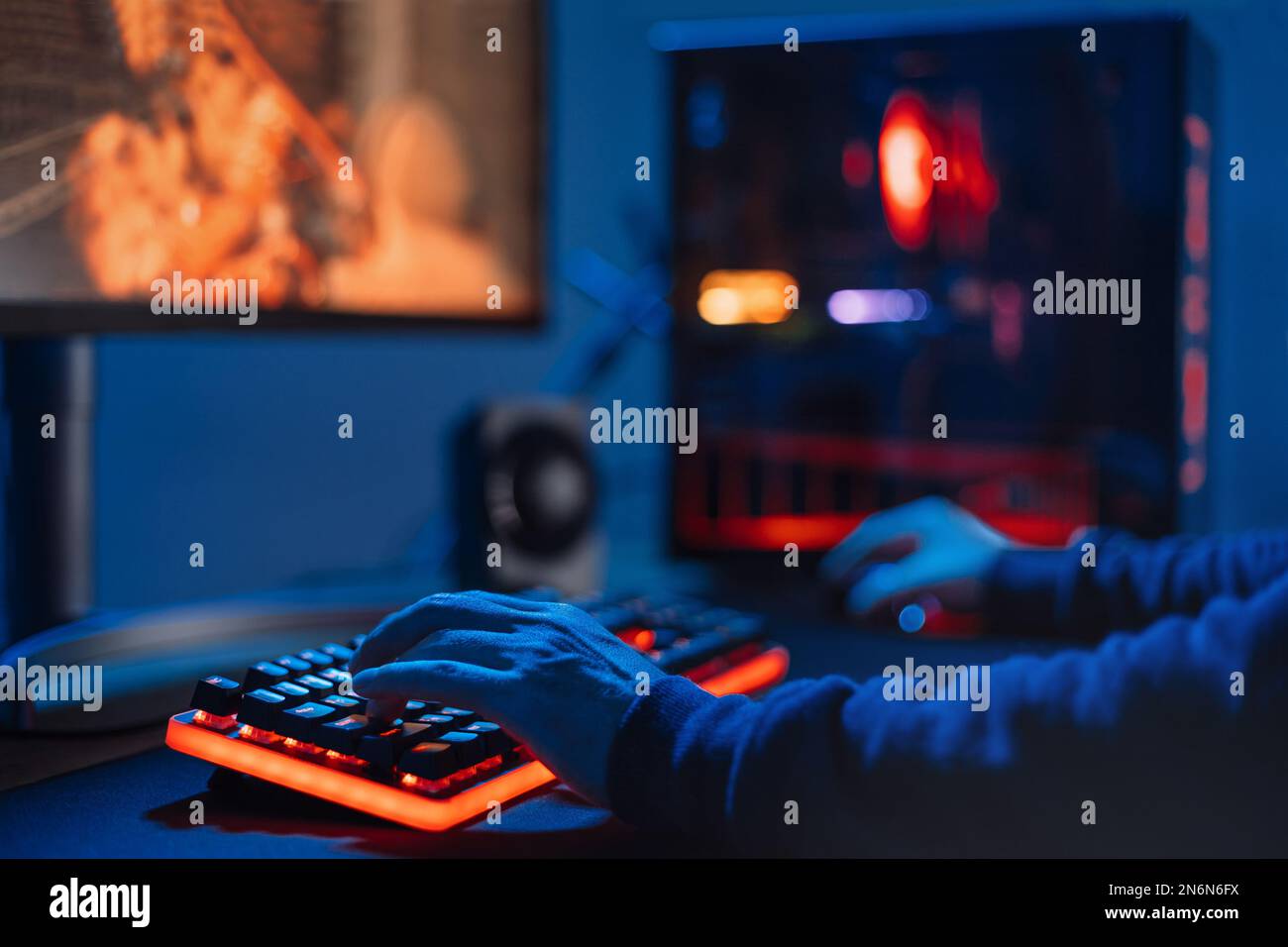 Close up of pro gamer's hands on keyboard in neon color, blur ...