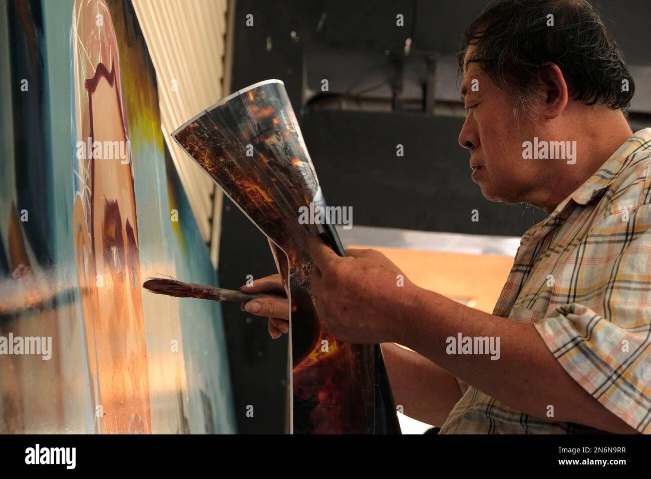 In this Friday, Sept. 6, 2013 photo, local artist Yan Jhen-fa paints a ...