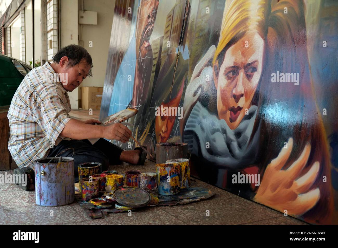 In this Friday, Sept. 6, 2013 photo, local artist Yan Jhen-fa paints a ...
