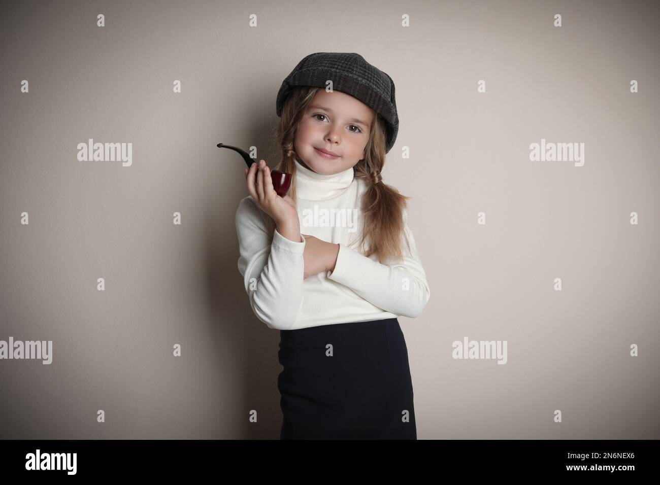 Cute little child in hat with smoking pipe playing detective on beige ...