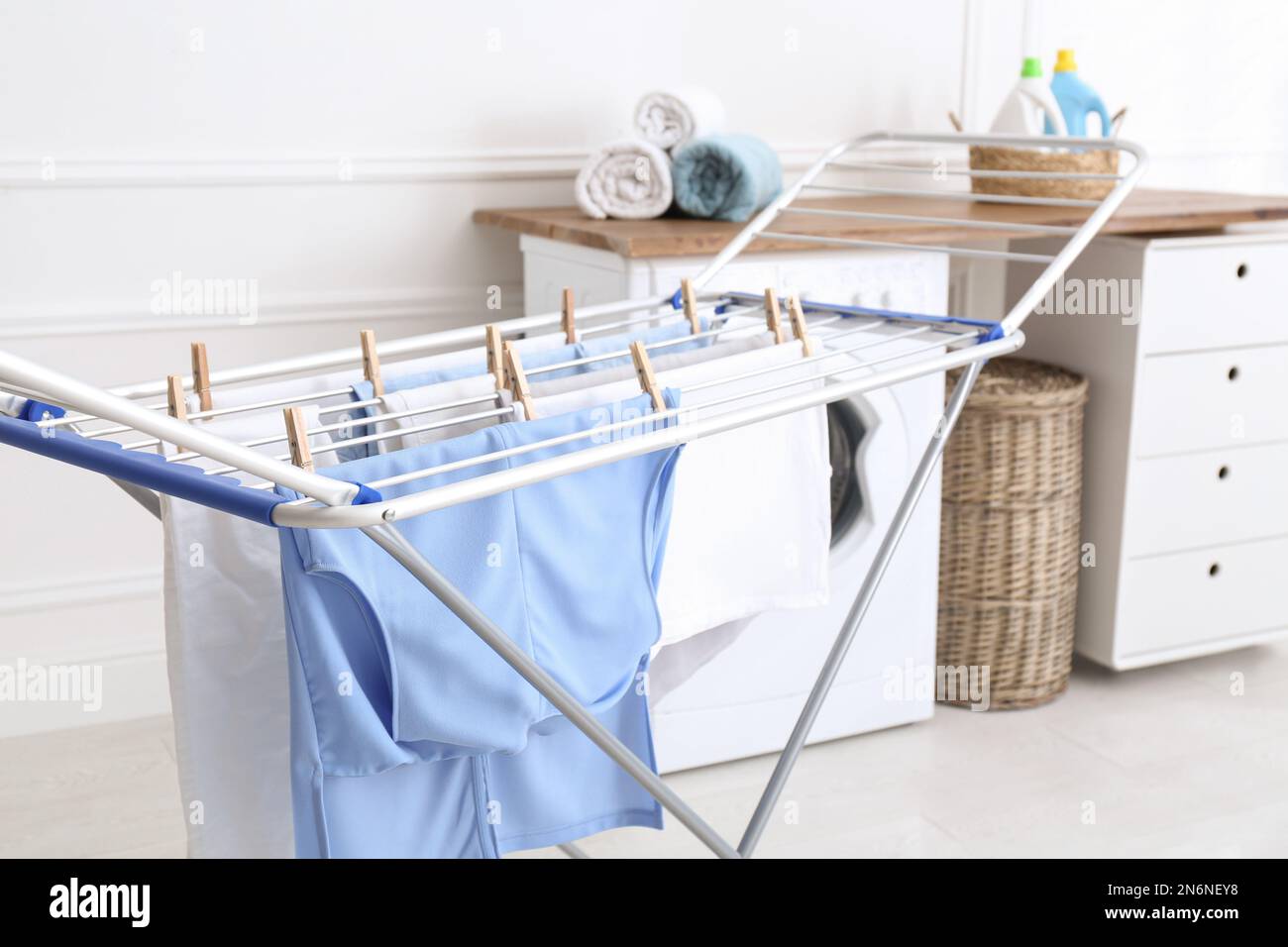 Clean laundry hanging on drying rack indoors Stock Photo - Alamy