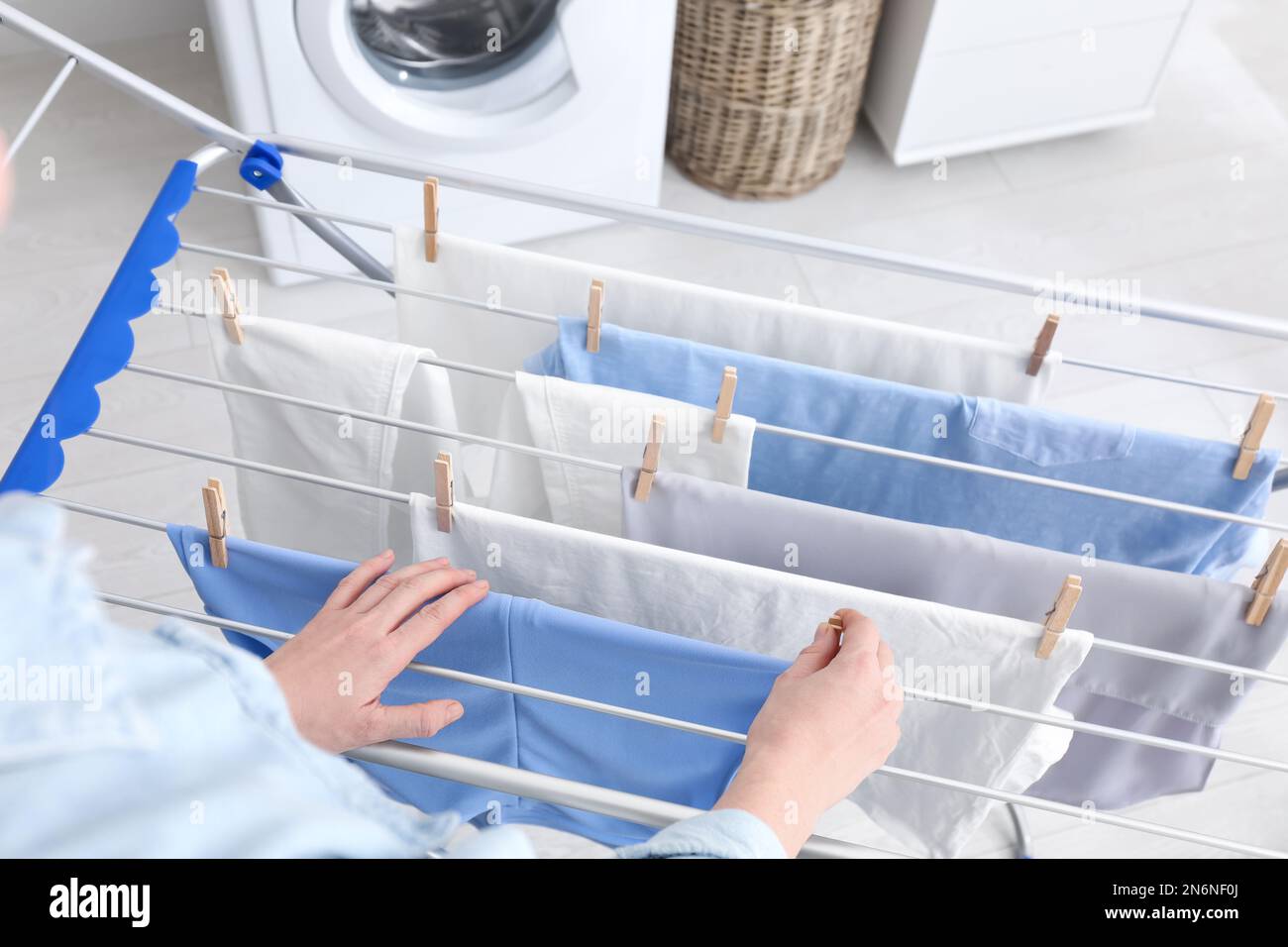 Woman hanging clean laundry on drying rack indoors, closeup Stock Photo ...