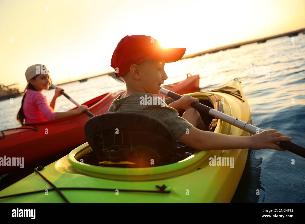 Happy children kayaking on river at sunset. Summer camp activity Stock ...