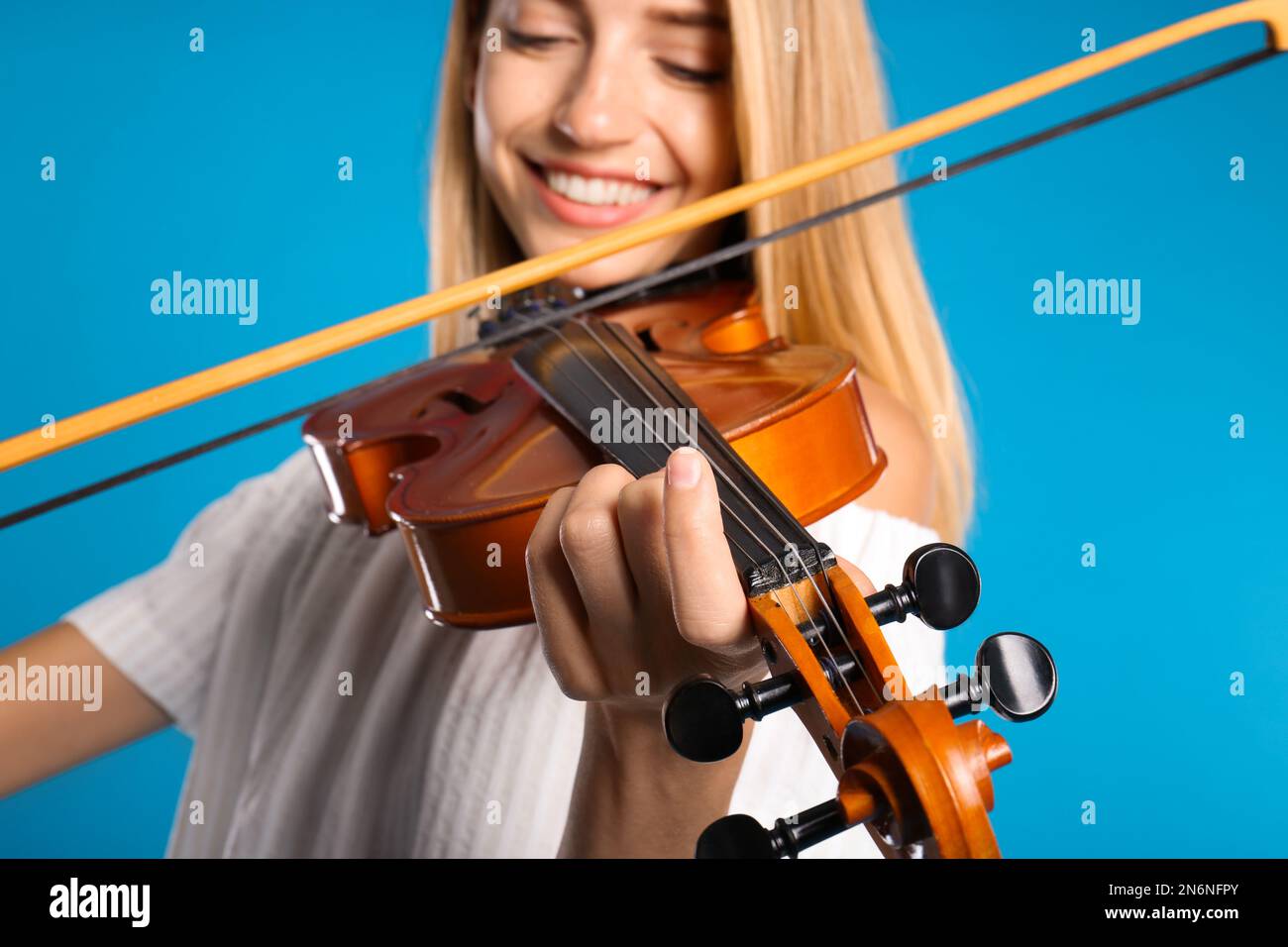 Beautiful woman playing violin on light blue background, closeup Stock ...