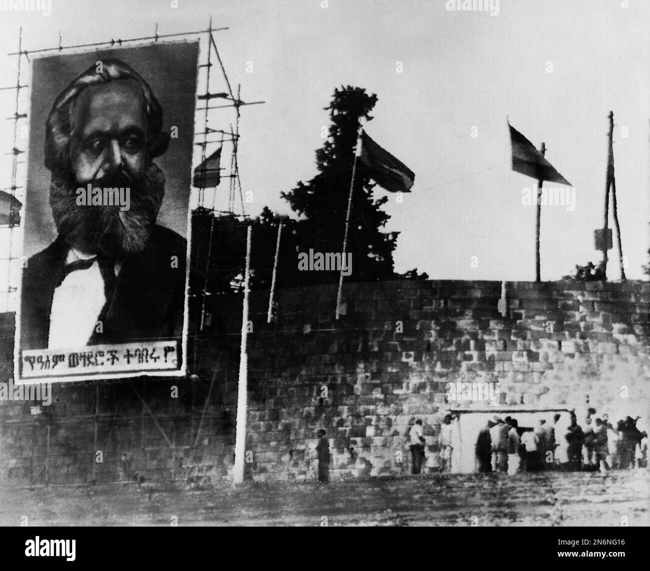 A giant picture of Karl Marx, left, overlooks workers at right who are ...