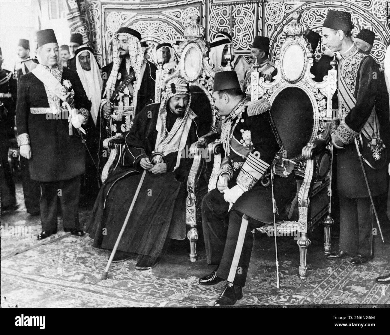 King Ibn Saud of Saudi Arabia, with walking stick, confers with King Farouk of Egypt against ...