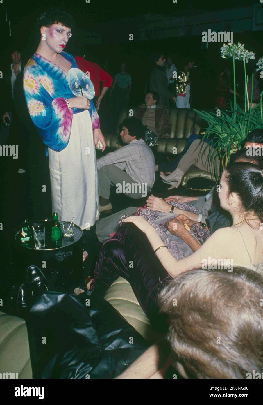 Brightly attired patron uses a fan to cool off in the lounge at New ...