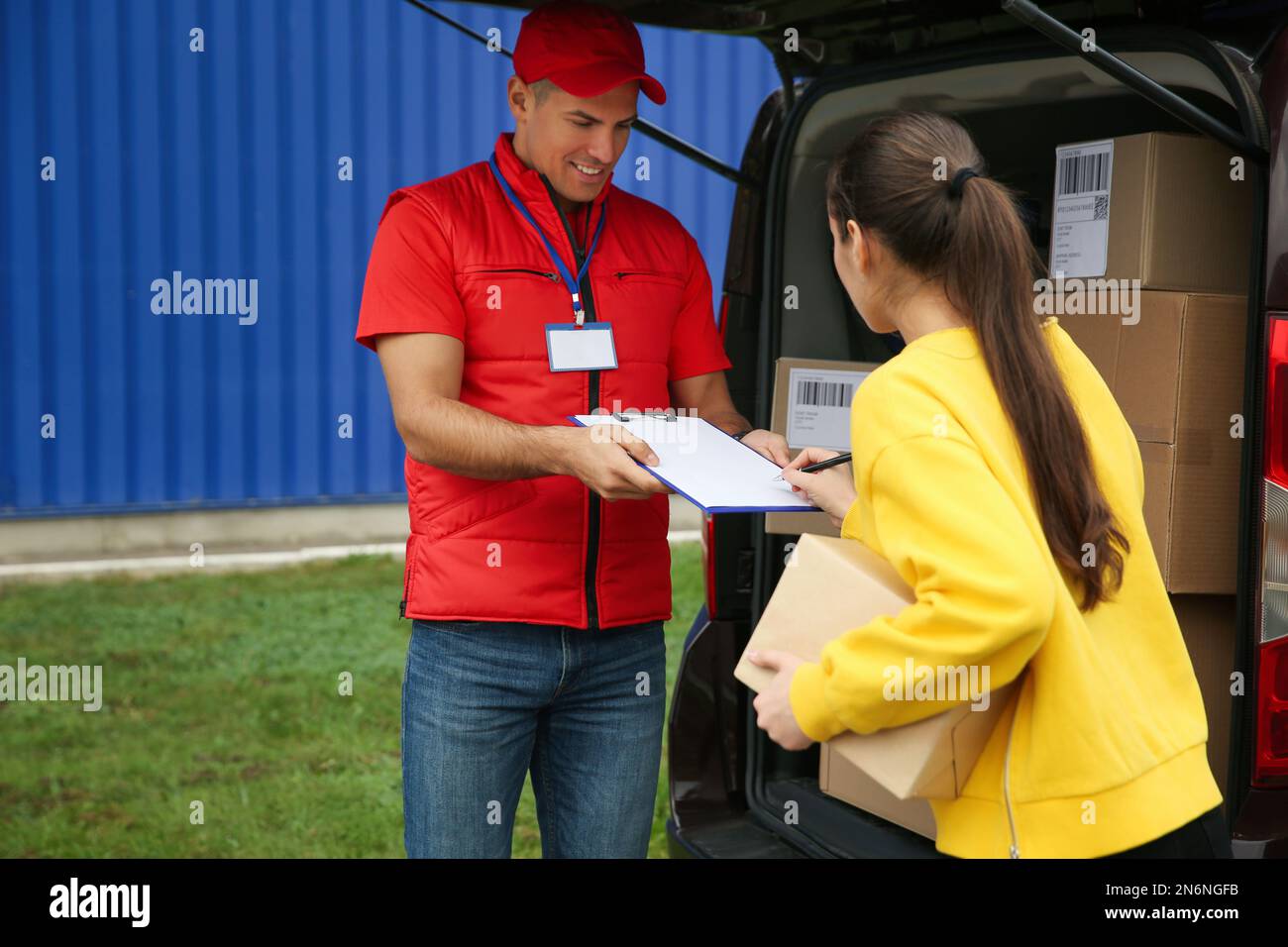 Courier receiving receipt signature from customer outdoors Stock Photo ...