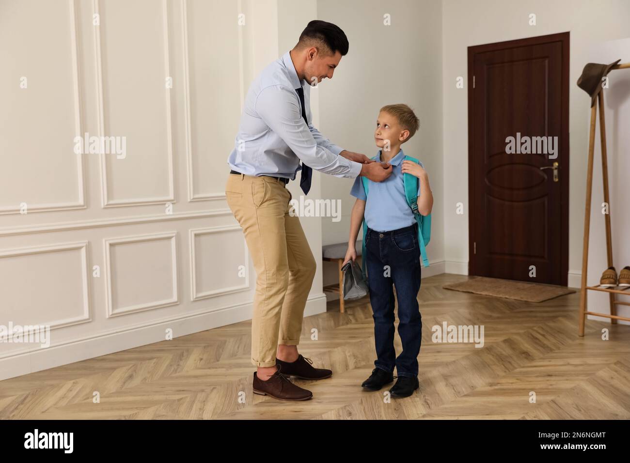 Father helping his little child get ready for school in hallway Stock ...