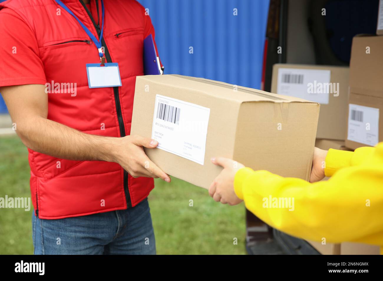 Courier giving package to customer outdoors, closeup Stock Photo - Alamy