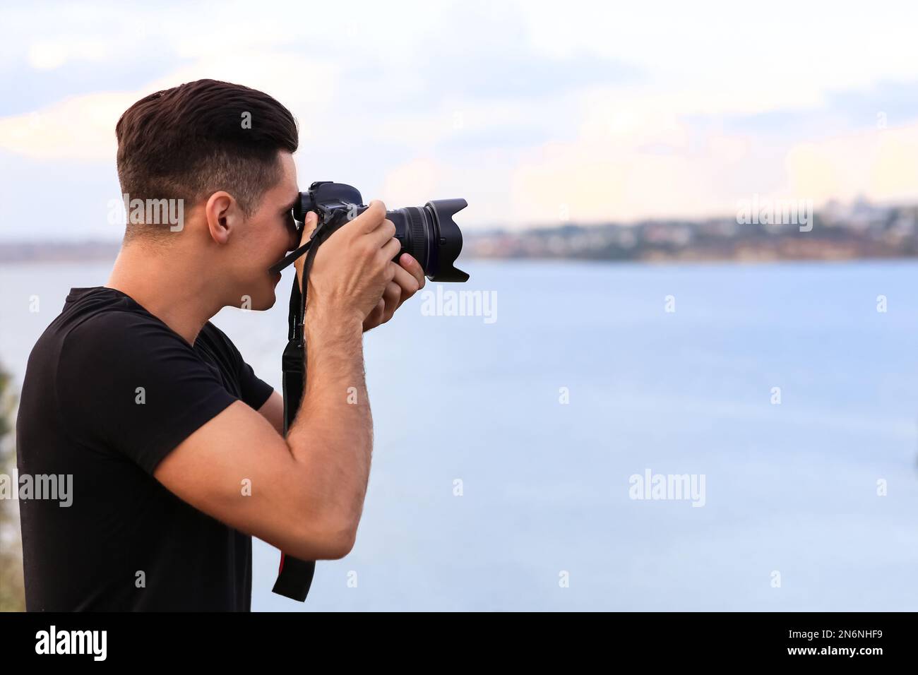 Photographer taking picture with professional camera near river Stock ...