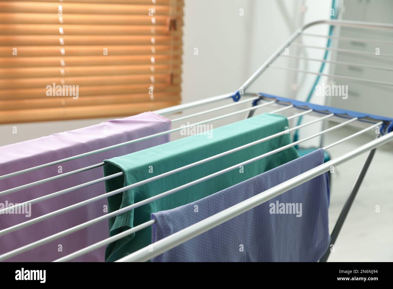 Clean laundry hanging on drying rack indoors, closeup Stock Photo - Alamy