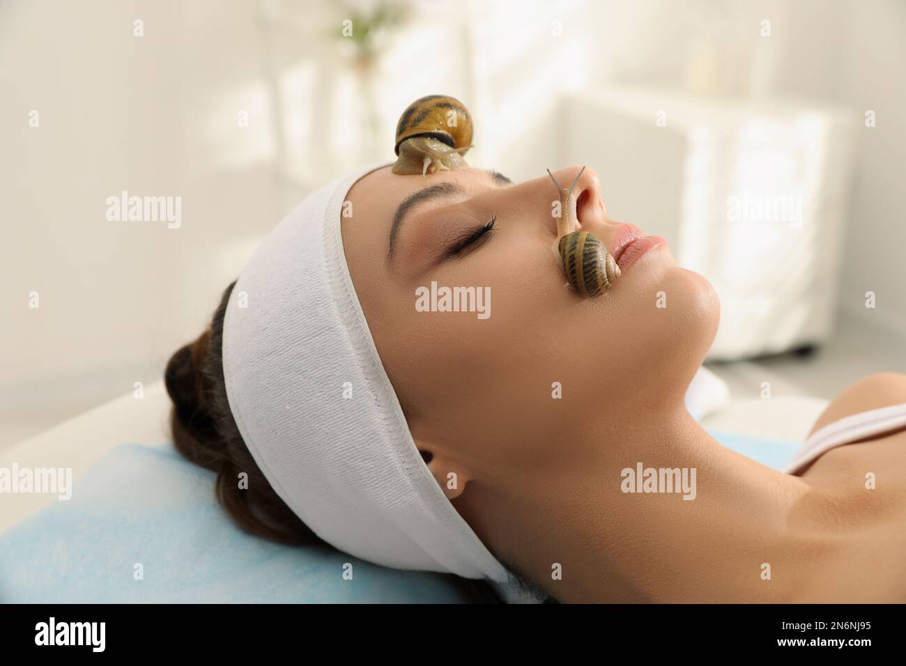 Young woman receiving snail facial massage in spa salon Stock Photo - Alamy