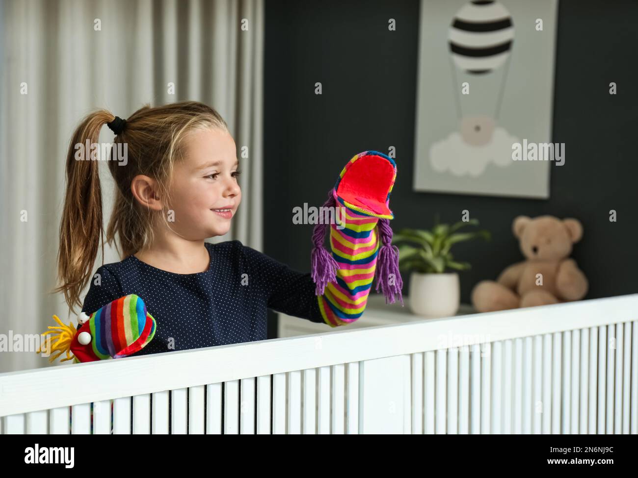 Cute little girl performing puppet show at home Stock Photo - Alamy