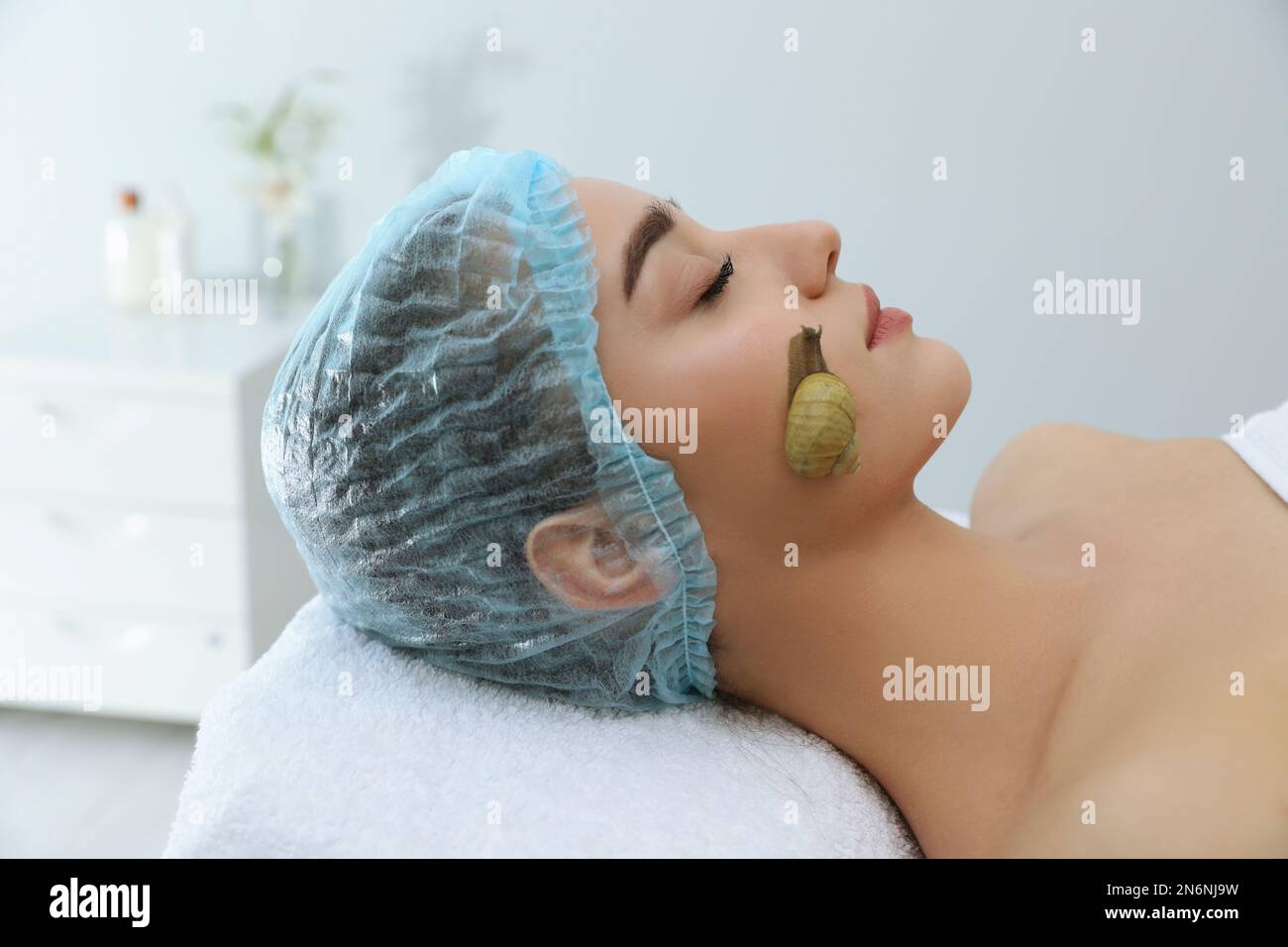 Young woman receiving snail facial massage in spa salon Stock Photo - Alamy