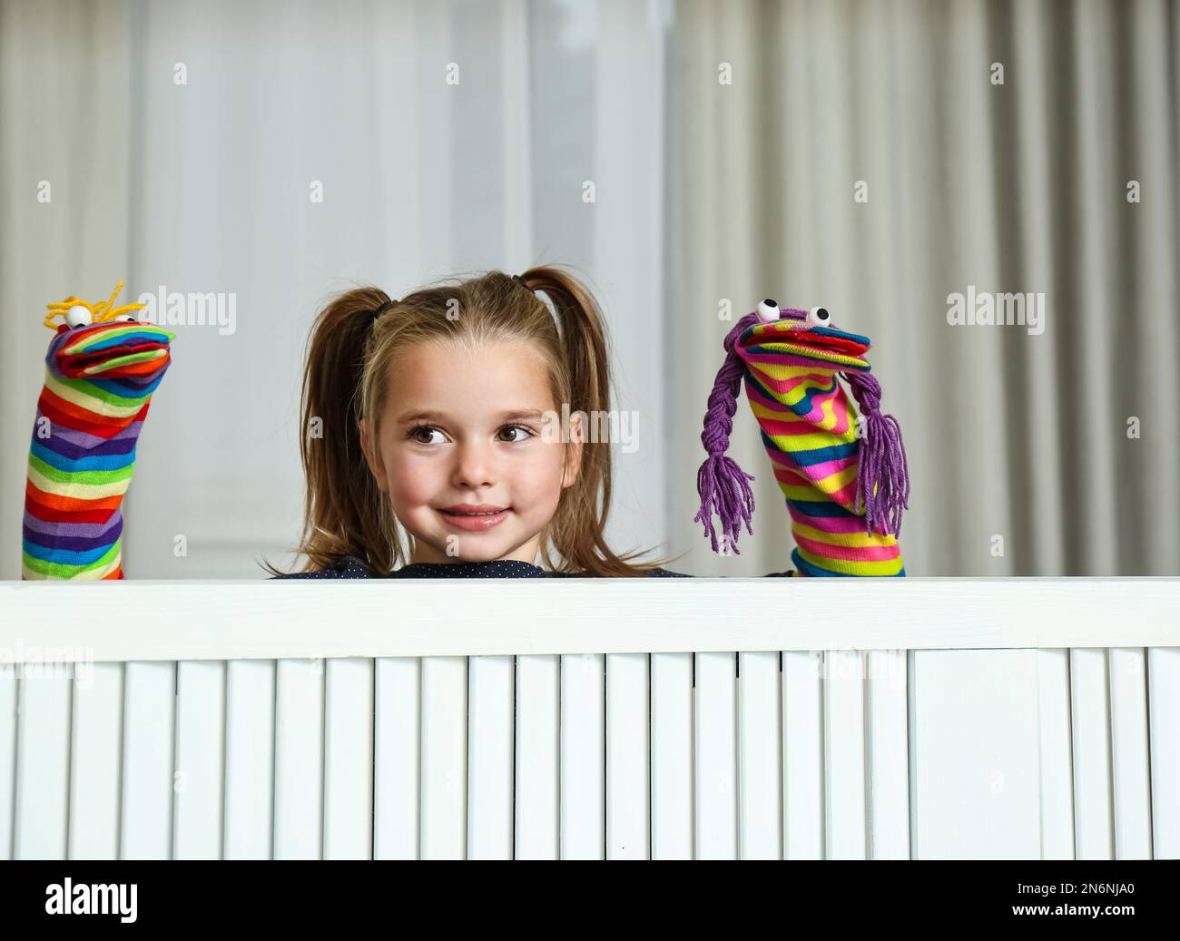 Cute little girl performing puppet show at home Stock Photo - Alamy