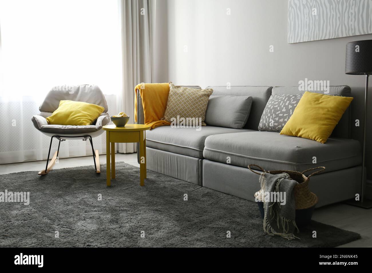 Stylish living room with sofa. Interior design in grey and yellow ...