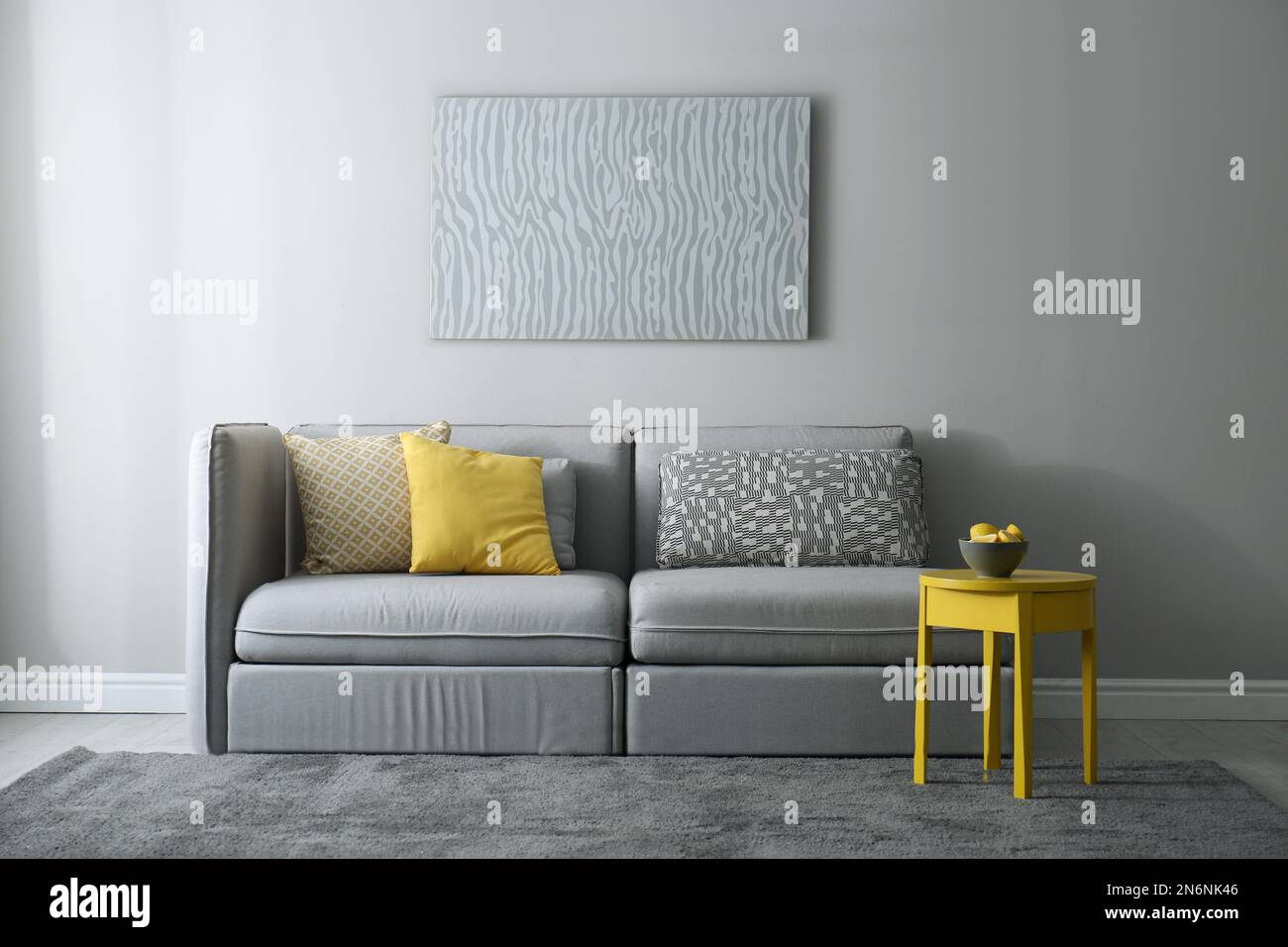 Stylish living room with sofa. Interior design in grey and yellow ...