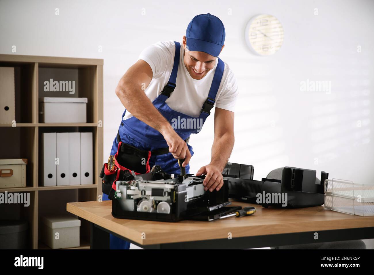 Repairman with screwdriver fixing modern printer in office Stock Photo ...