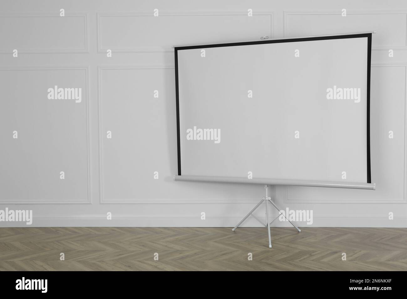 Blank projection screen near white wall indoors. Space for design Stock ...