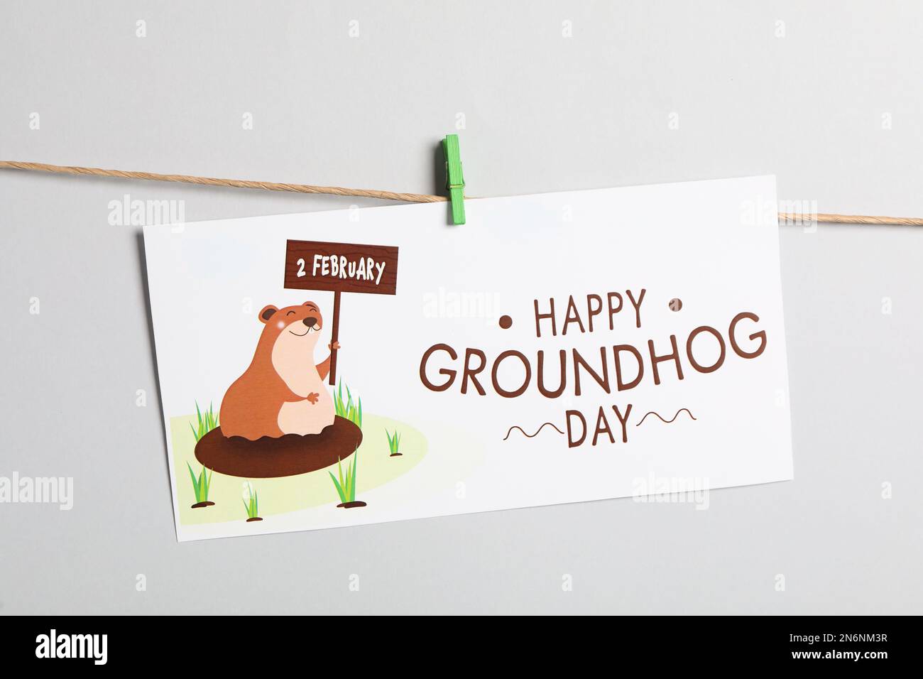 Happy Groundhog Day greeting card hanging on light background Stock ...
