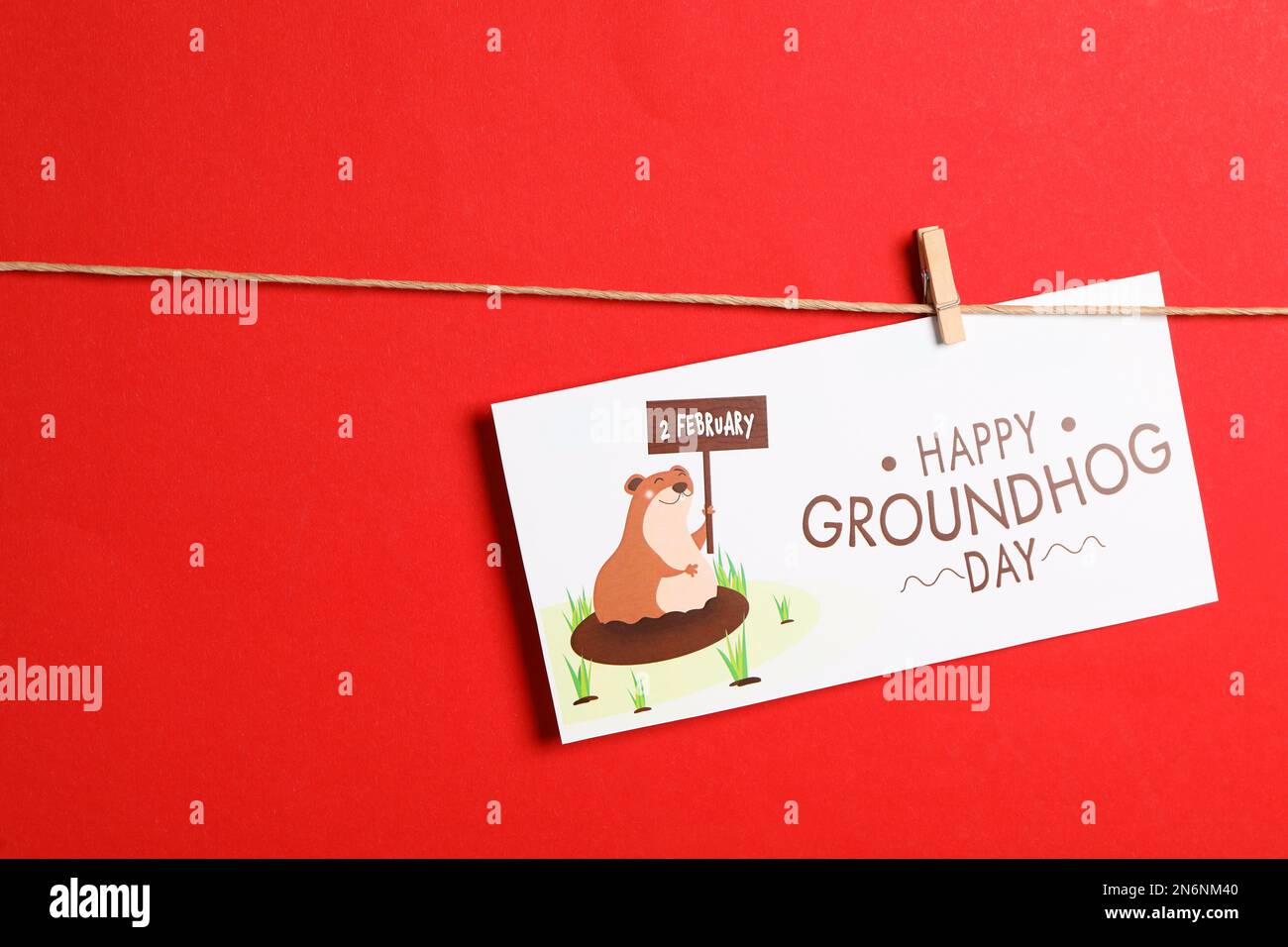 Happy Groundhog Day greeting card hanging on red background, space for ...