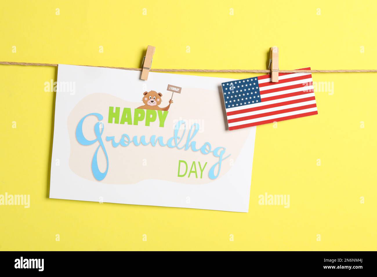 Happy Groundhog Day greeting card and American flag hanging on yellow ...