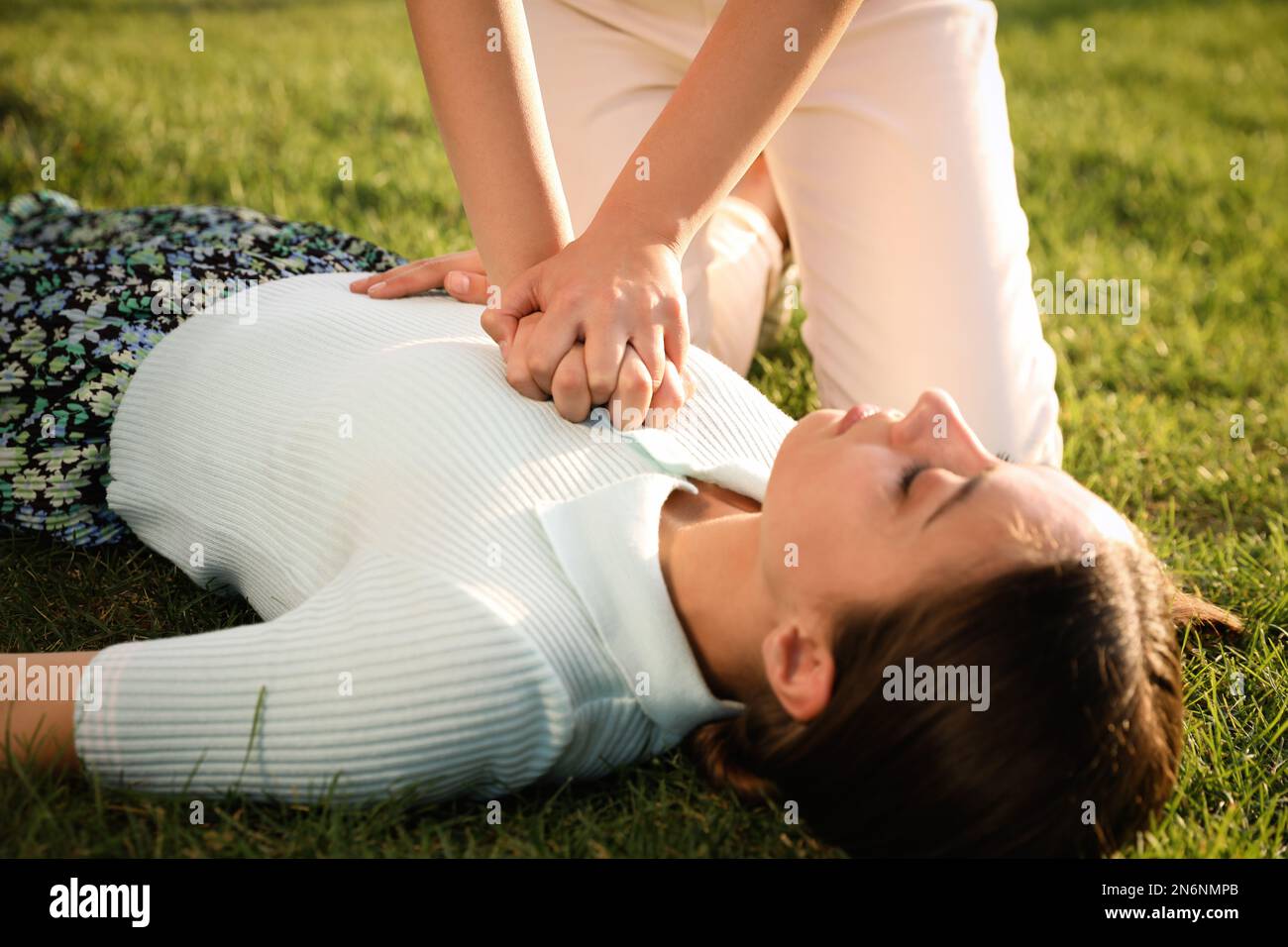 Woman doing cardiac massage to unconscious person with heart attack on ...
