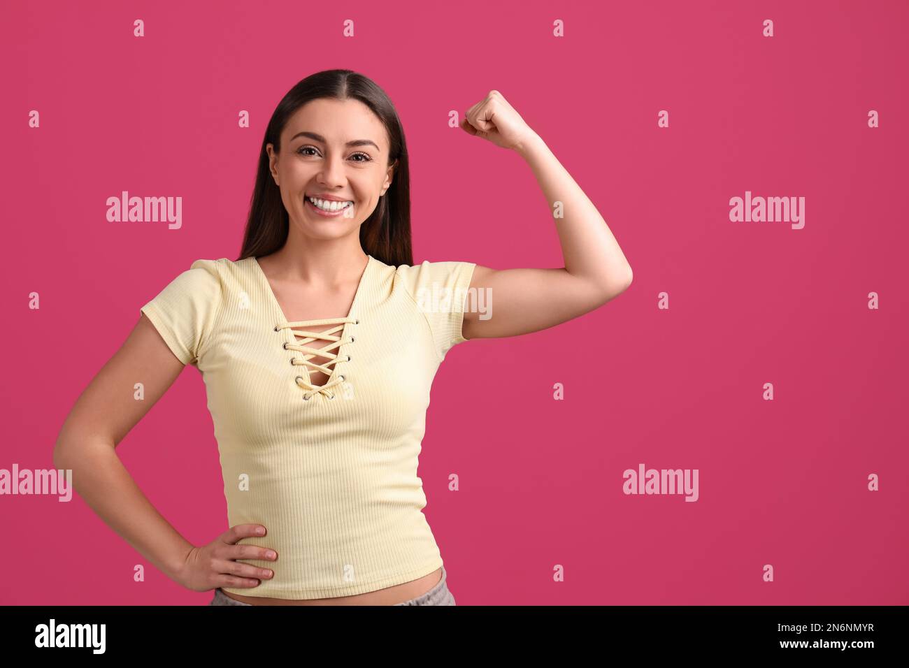 Strong woman as symbol of girl power on pink background, space for text ...