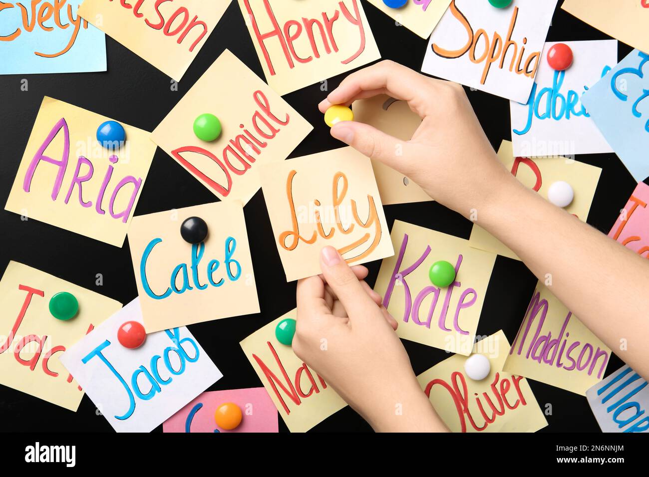 Woman putting notes with baby names on board, closeup Stock Photo - Alamy