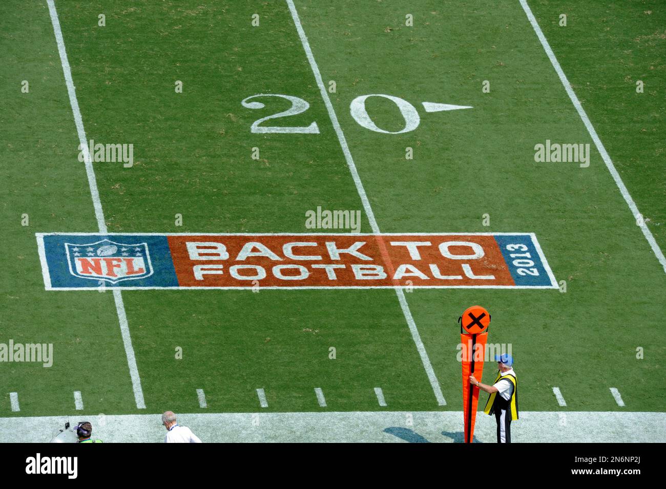 An official stands on the sideline next to the Back to Football signage ...