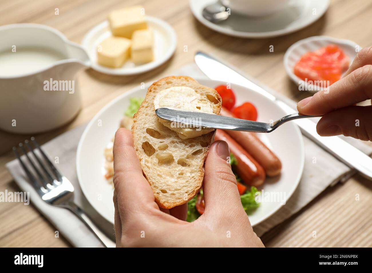 Woman spreading butter on toast at table, closeup. Buffet service Stock ...