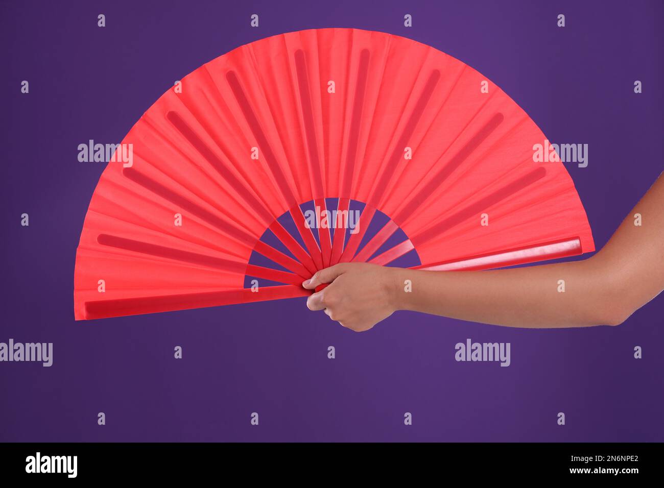 Woman holding red hand fan on purple background, closeup Stock Photo ...