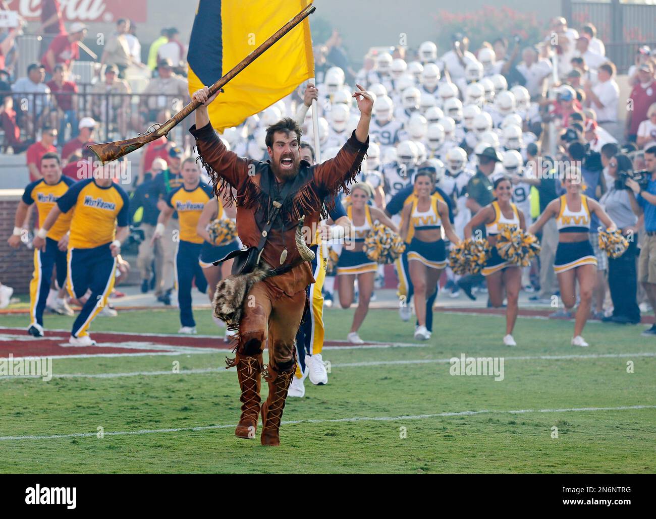 West Virginia Mountaineer mascot Jonathan Kimble leads the cheerleaders ...