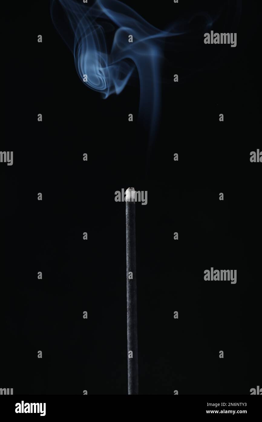 Incense stick smoldering on black background, closeup Stock Photo - Alamy