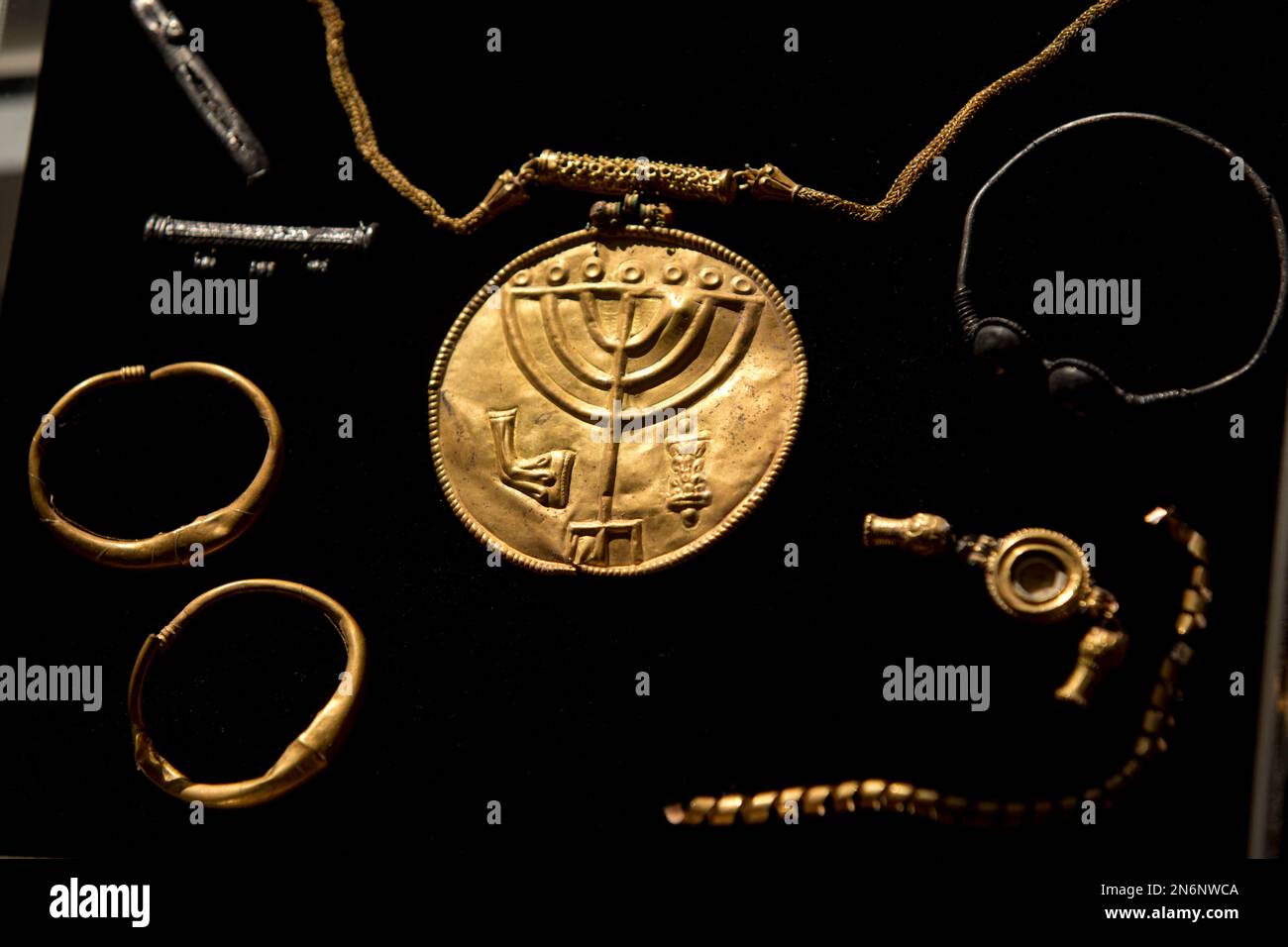 Jewelry and a gold medallion with the Jewish menorah symbol etched into ...