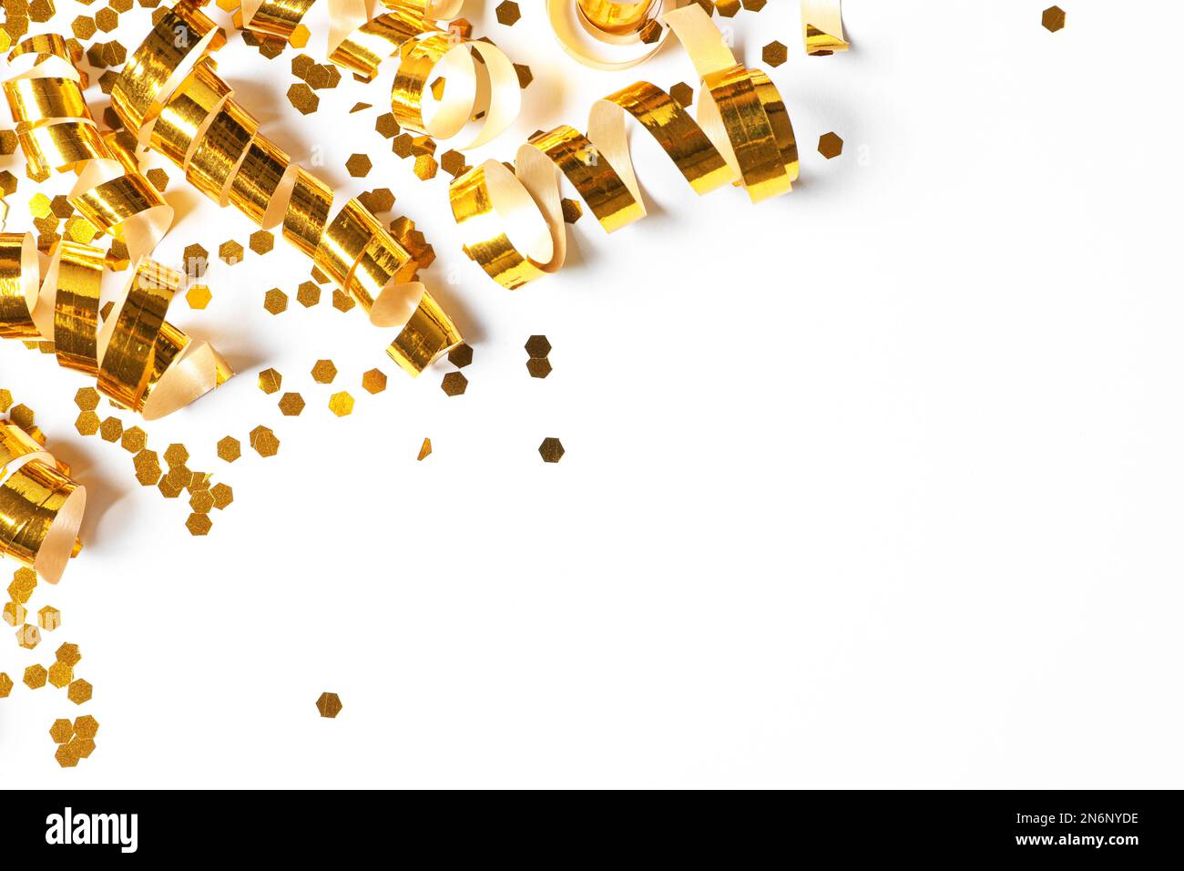 Shiny golden serpentine streamers and confetti on white background, top ...