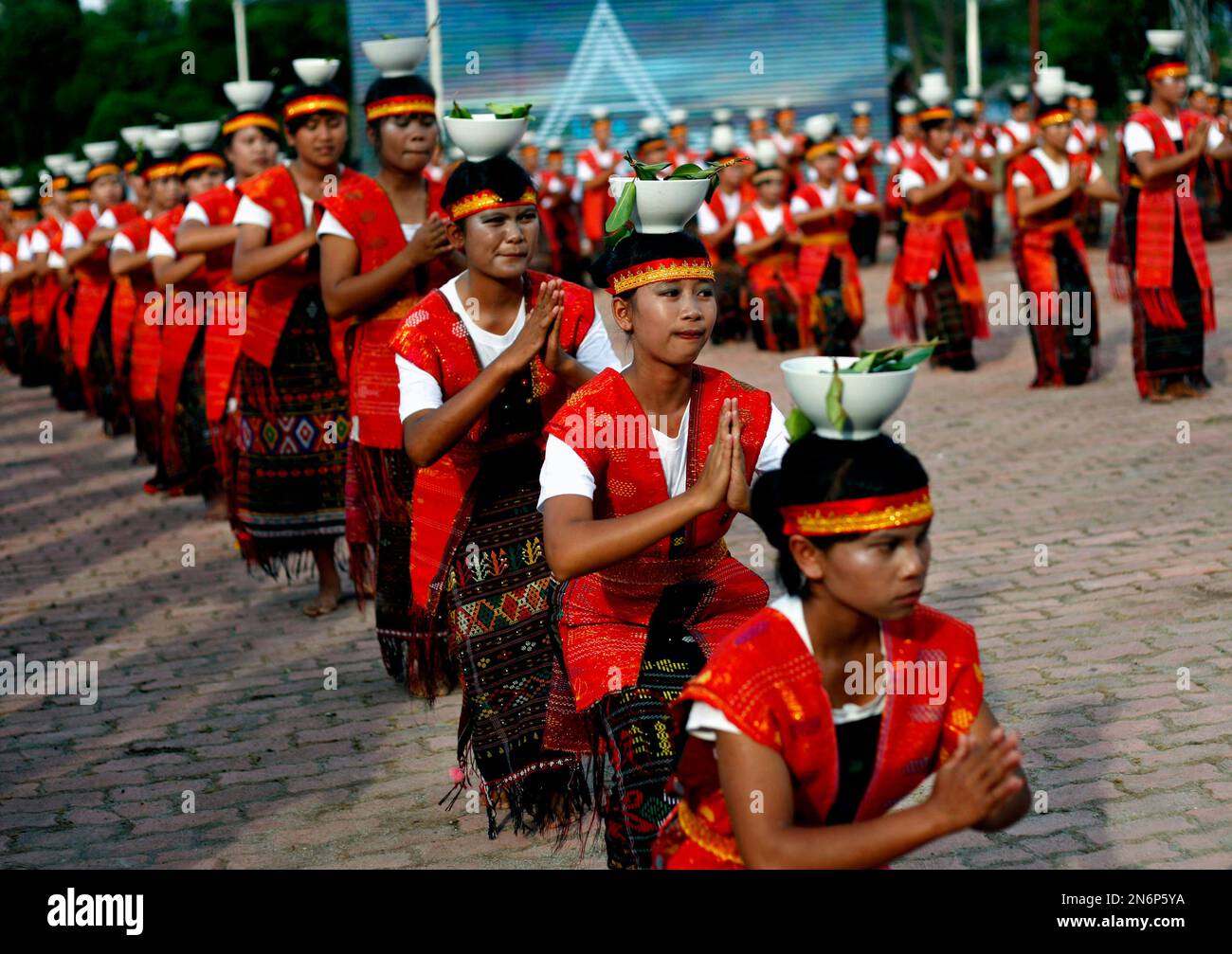 Indonesian girls put bowls of holy water on their head as they perform ...