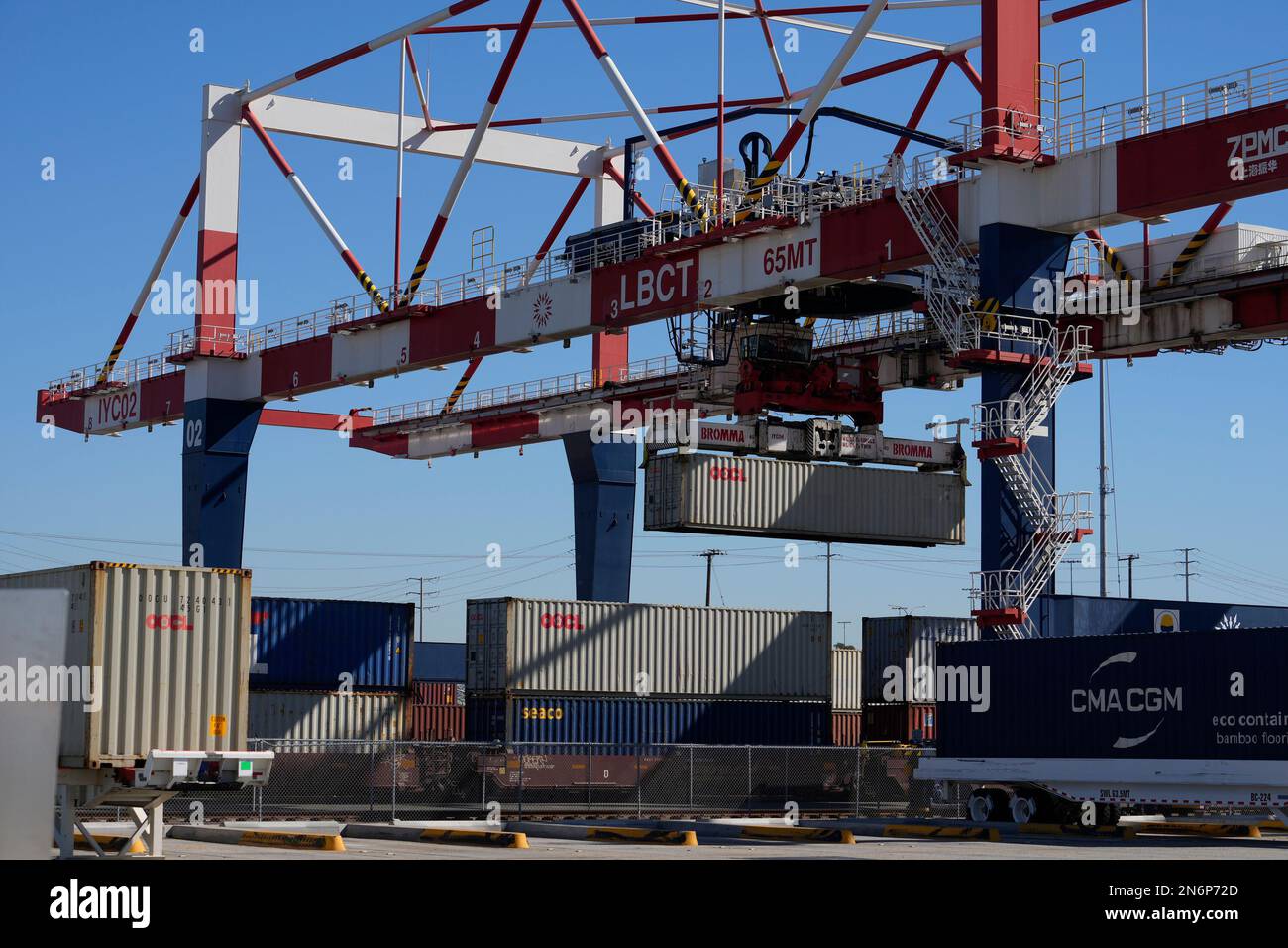 A large crane lifts shipping containers onto 2-mile-long train at the ...