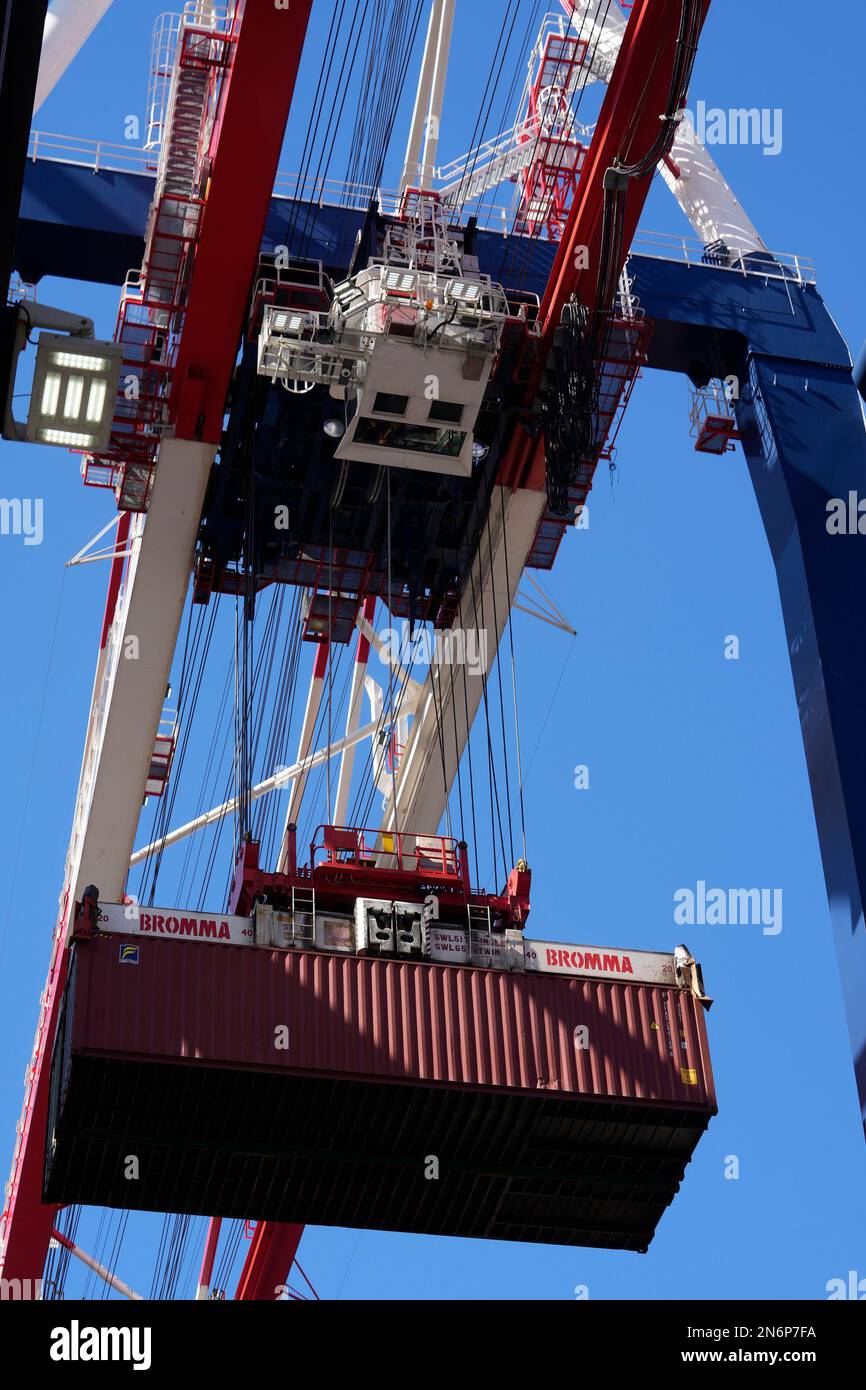 Large, active computer-controlled cargo cranes rapidly lift containers from ships to zero ...