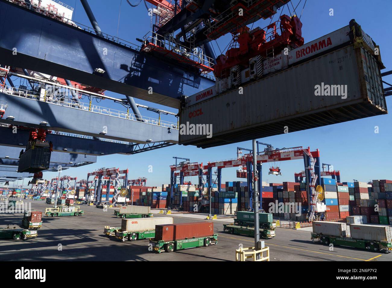 Large, active computer-controlled cargo cranes rapidly lift containers ...